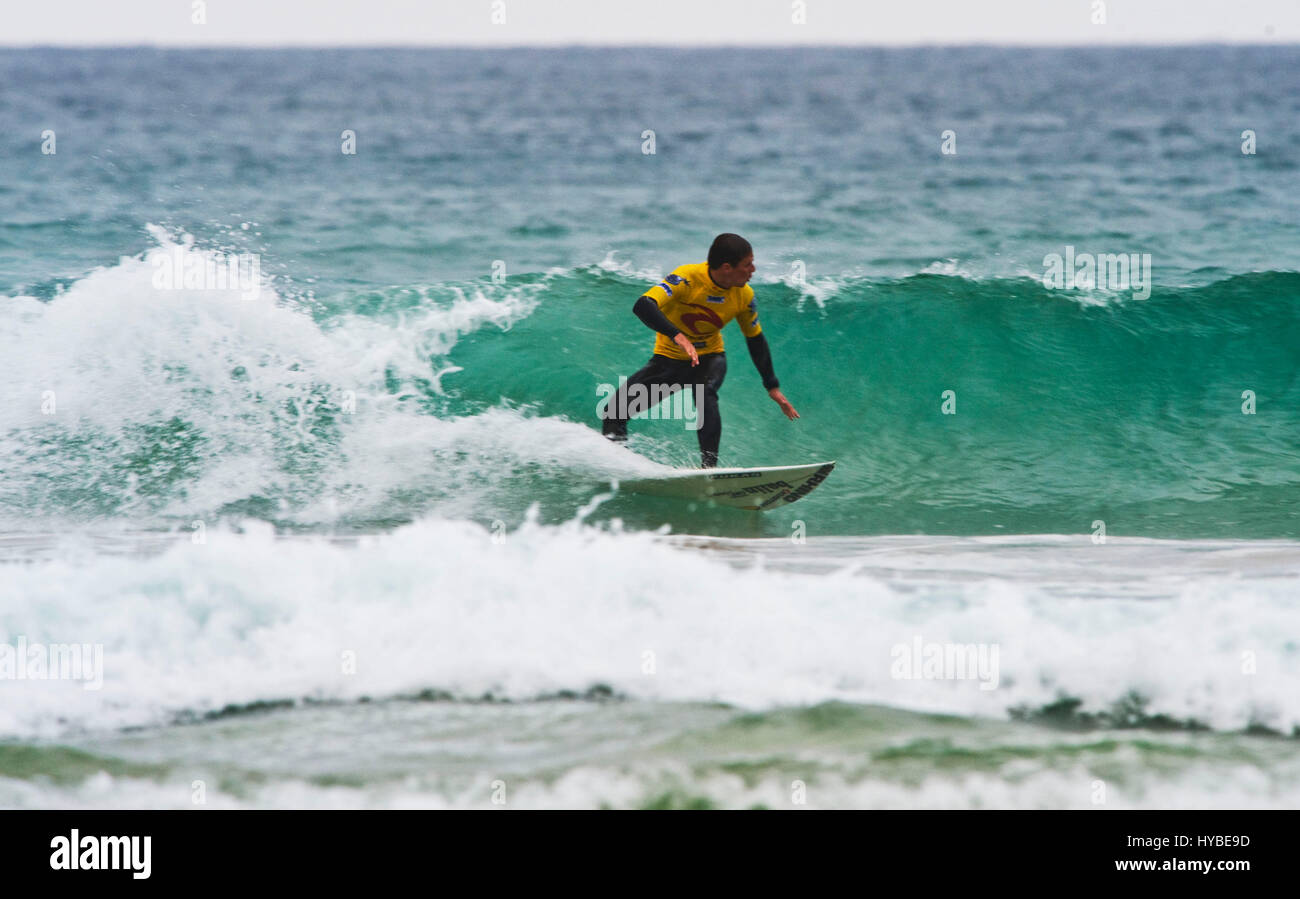 Surfer cutting into wave and riding low Stock Photo - Alamy