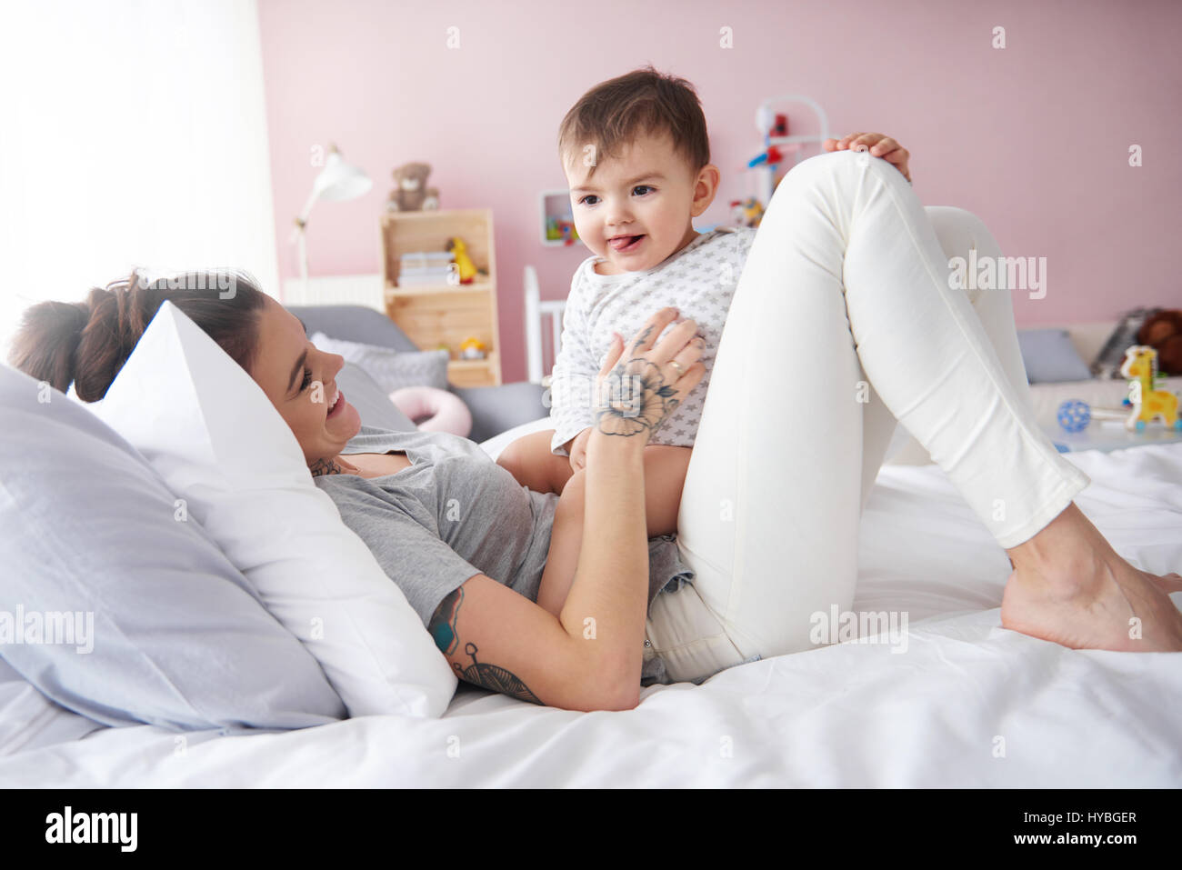 Playful mummy with baby boy on the bed Stock Photo - Alamy