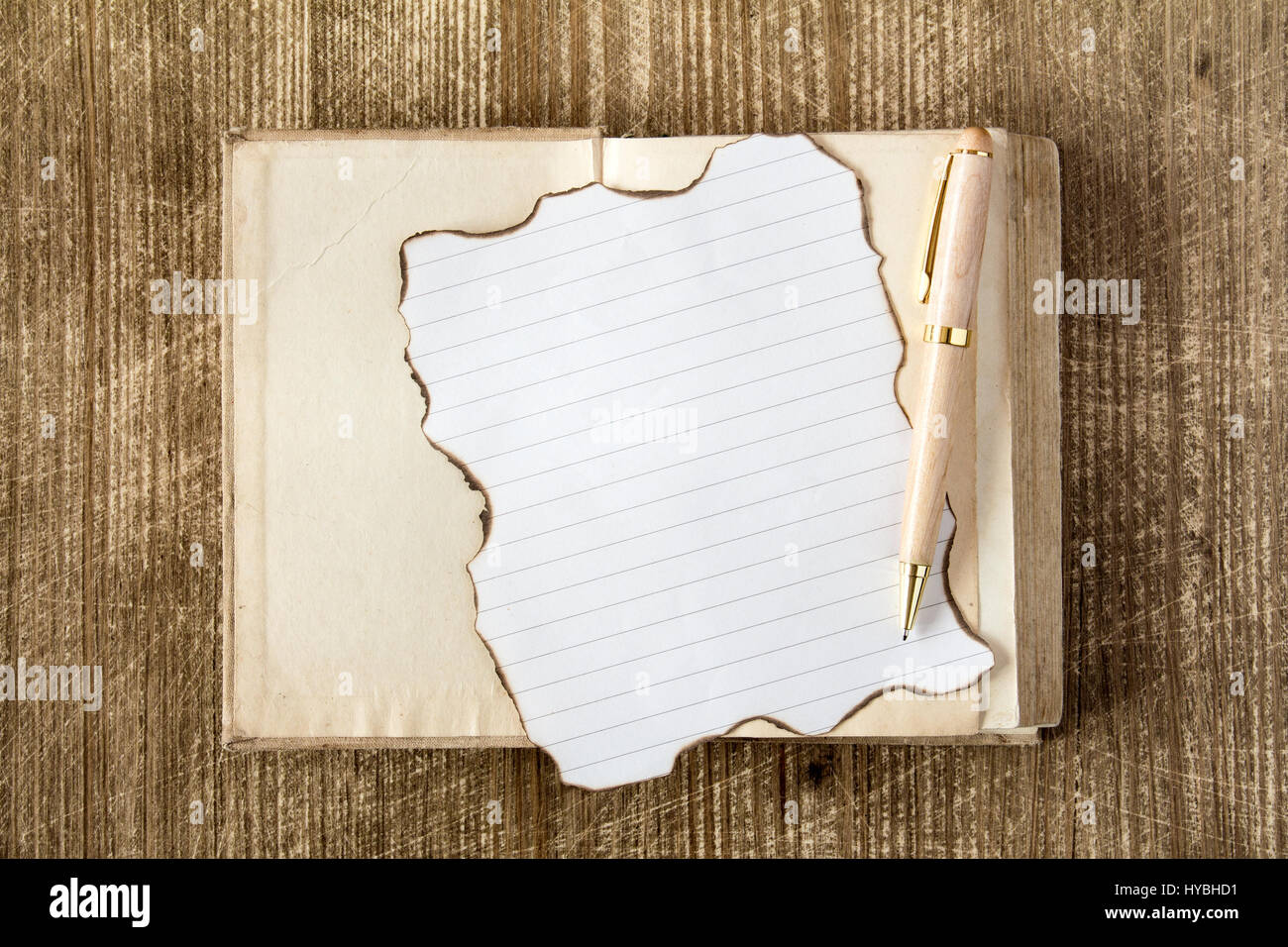 Old book with burned letter on the wooden background Stock Photo - Alamy