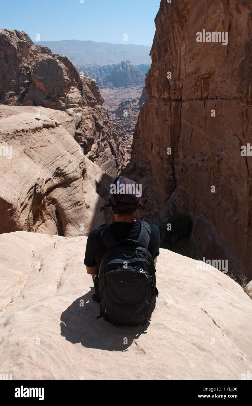 Jordan: a man seated on a rock looking at jordanian landscape on the ...