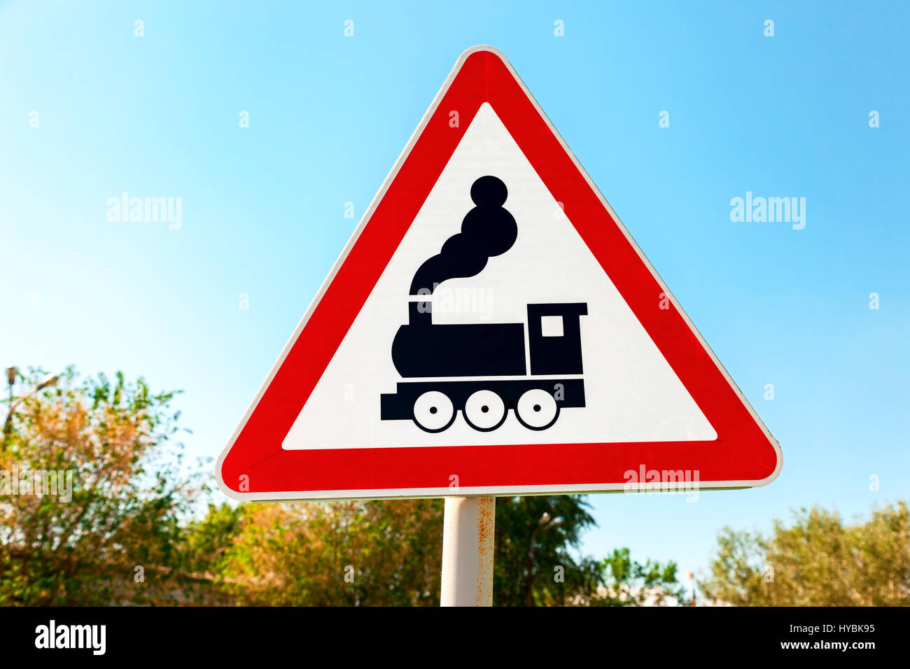 Traffic warning sign with train symbol against the blue sky background ...