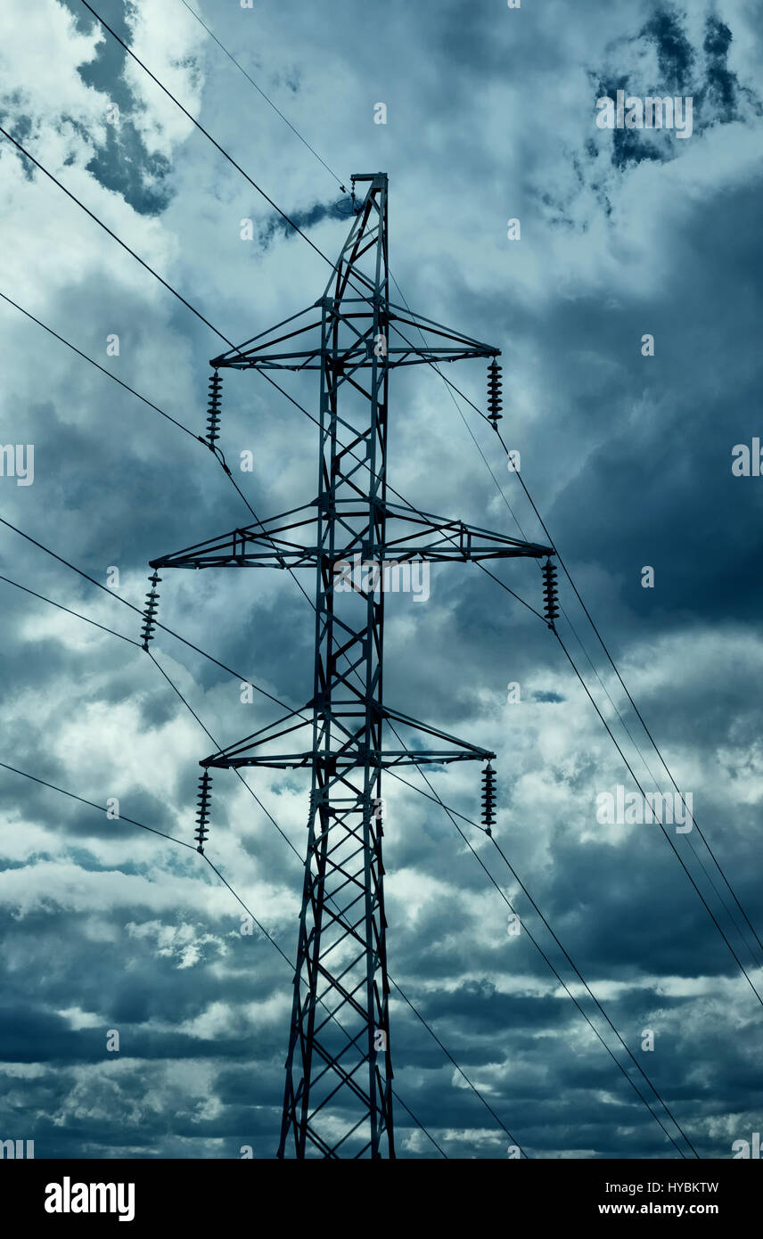 High-tension power line with dark clouds Stock Photo - Alamy