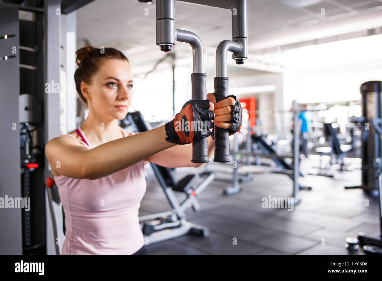 Young woman doing butterfly exercise in the fitness center Stock Photo ...