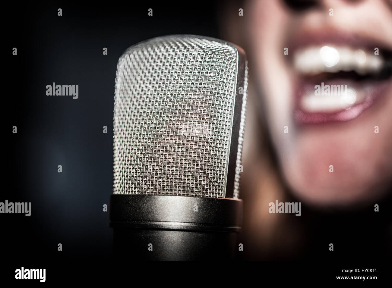 woman speaking or singing with a microphone Stock Photo - Alamy