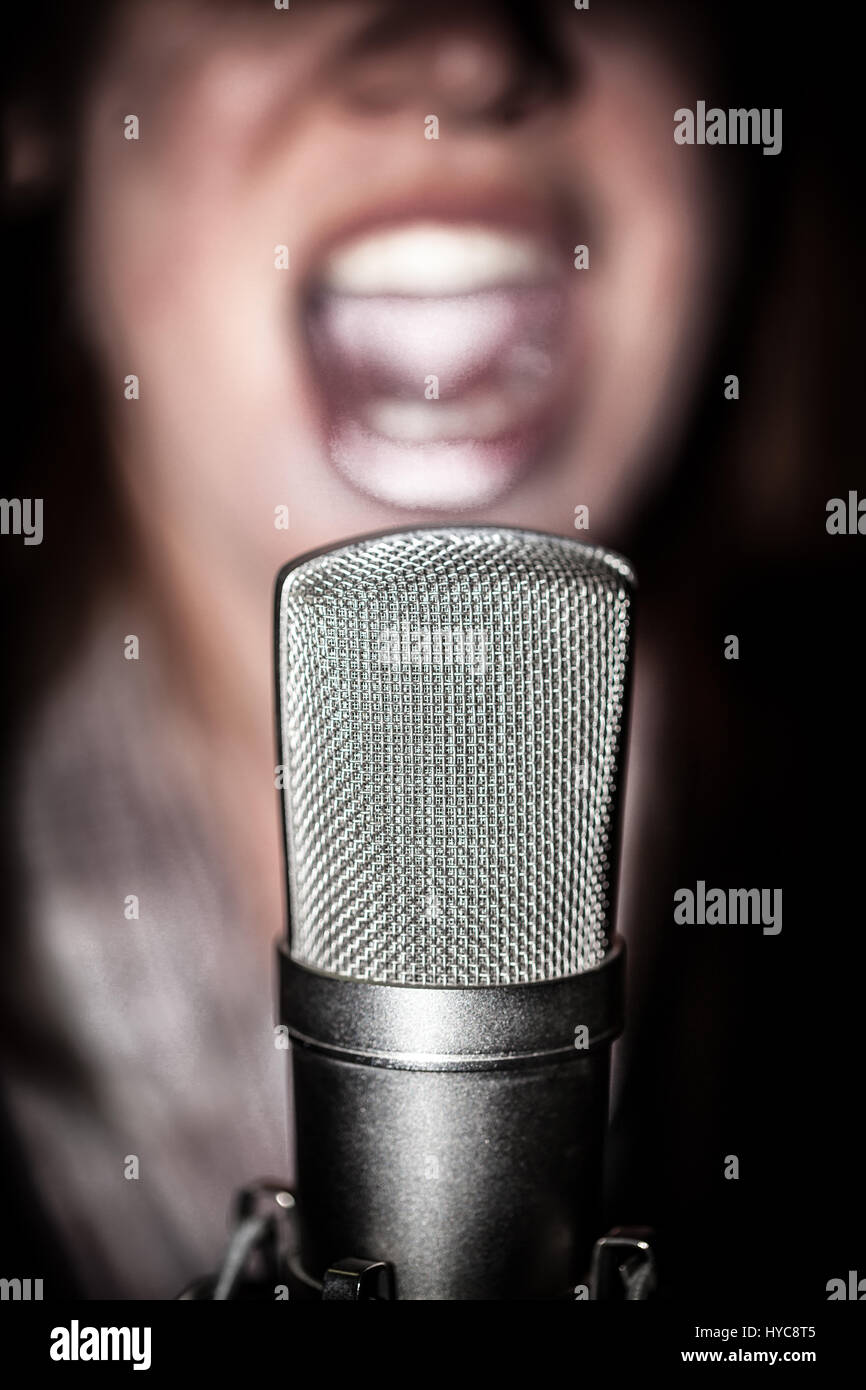 woman speaking or singing with a microphone Stock Photo - Alamy