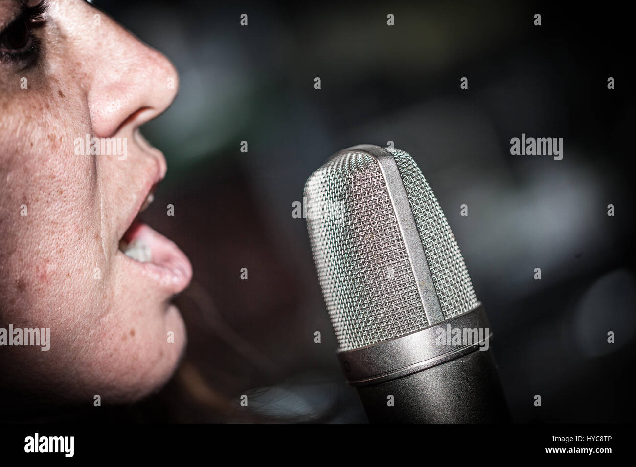 woman speaking or singing with a microphone Stock Photo - Alamy