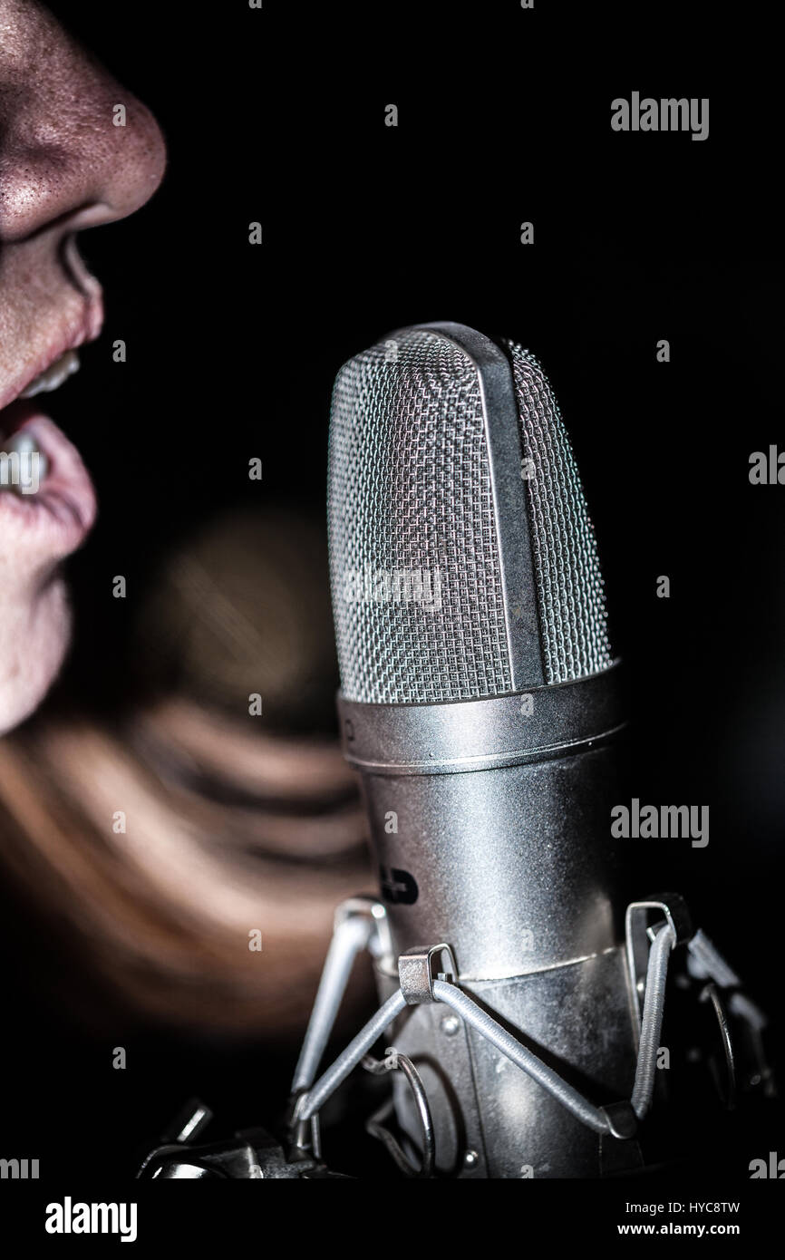 woman speaking or singing with a microphone Stock Photo - Alamy