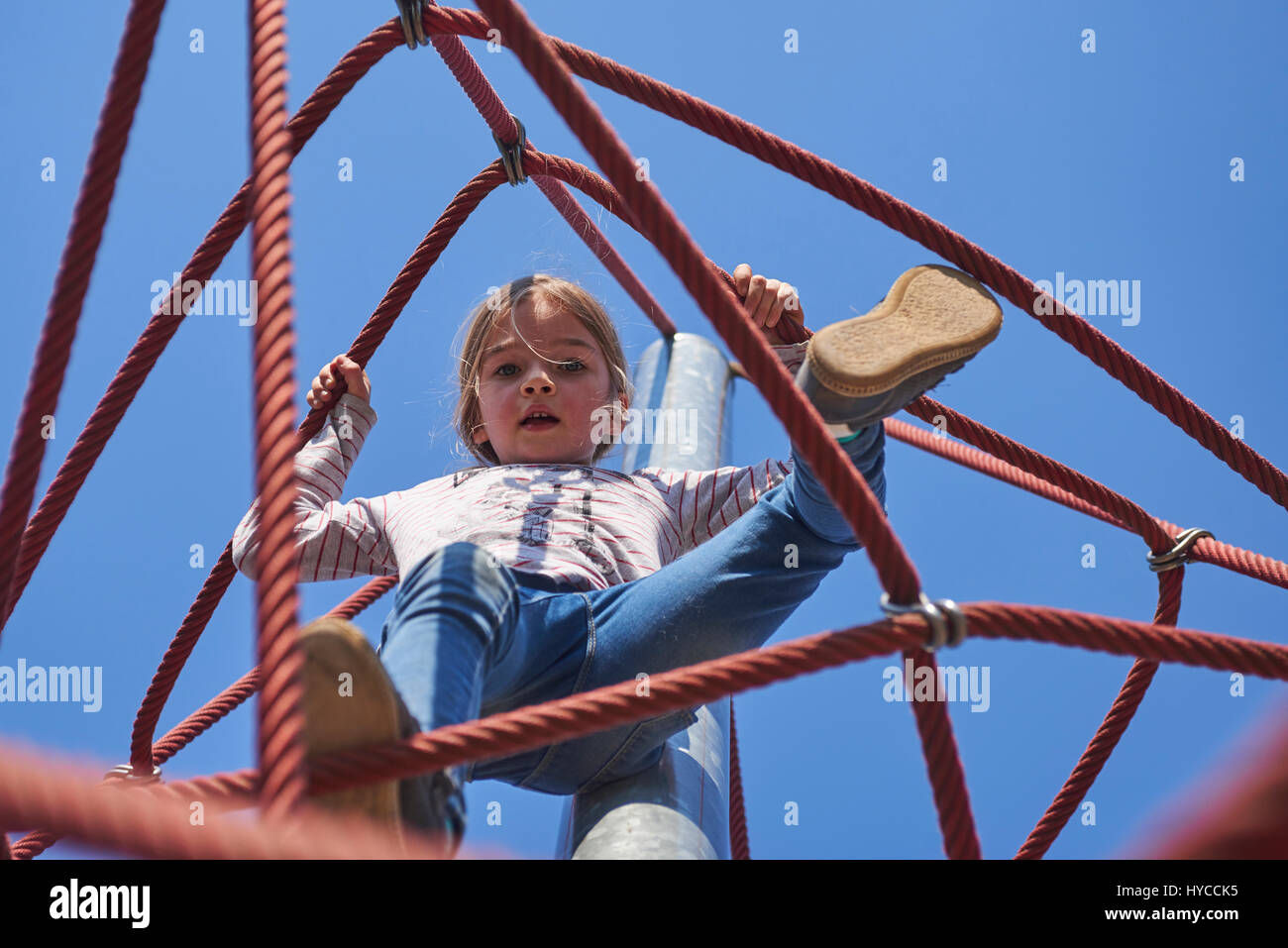 Active young child girl climbing the spider web playground activity ...