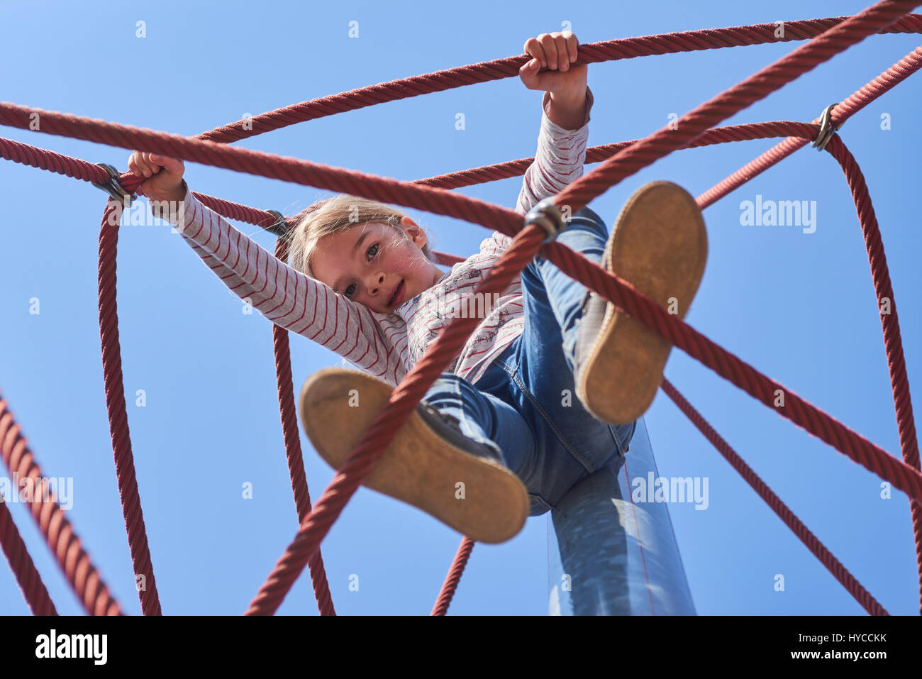 Active young child girl climbing the spider web playground activity ...