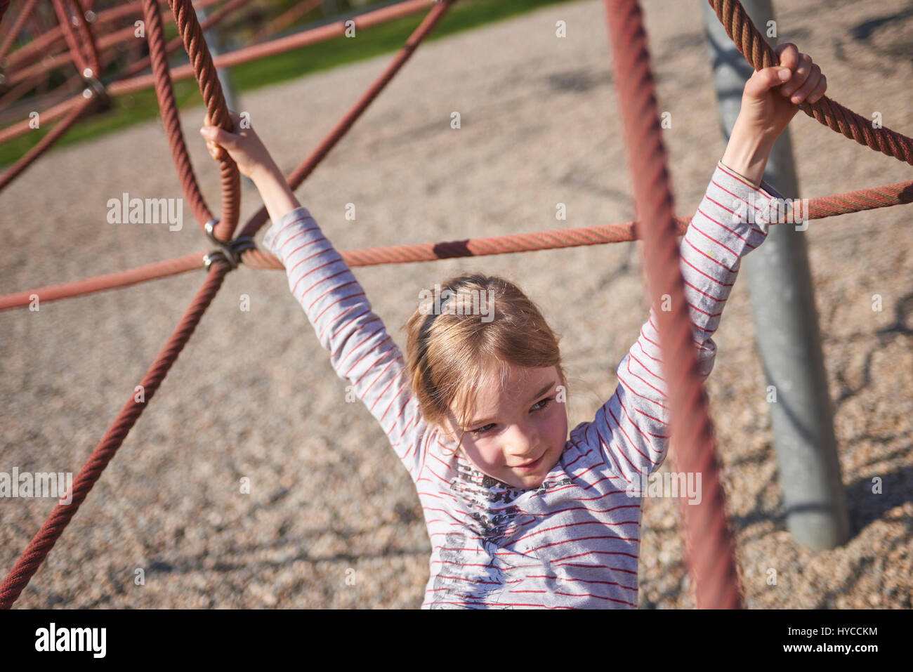 Active young child girl climbing the spider web playground activity ...