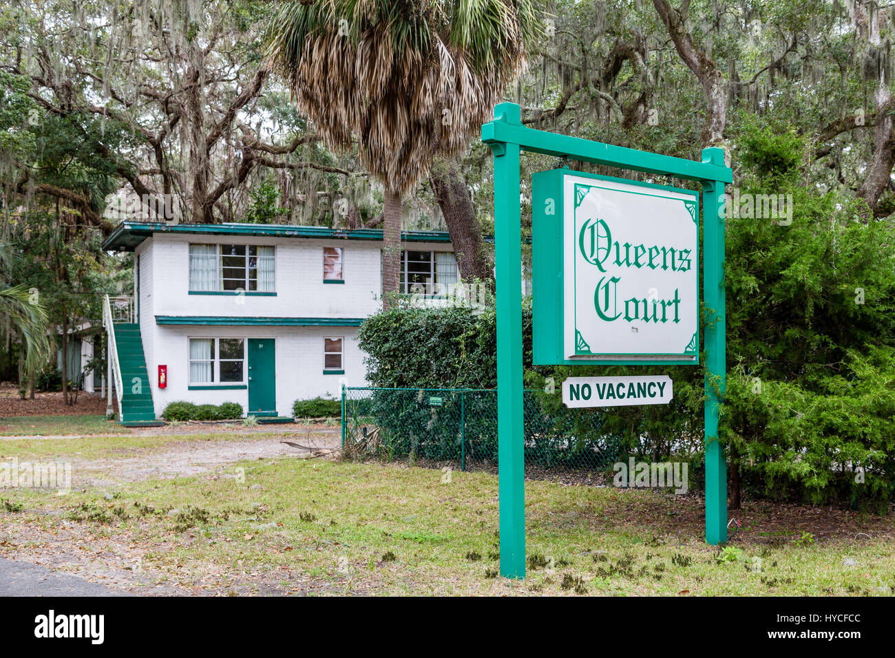 An old deserted and closed white cinder block and green motel under ...