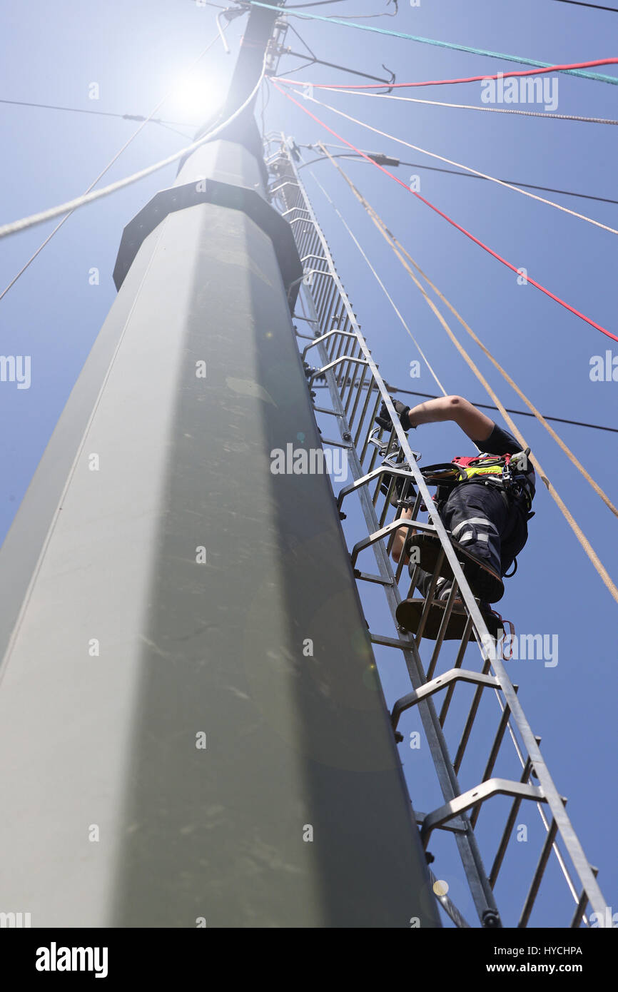 Rescue team paramedic climbing up a high voltage power line pylon ...