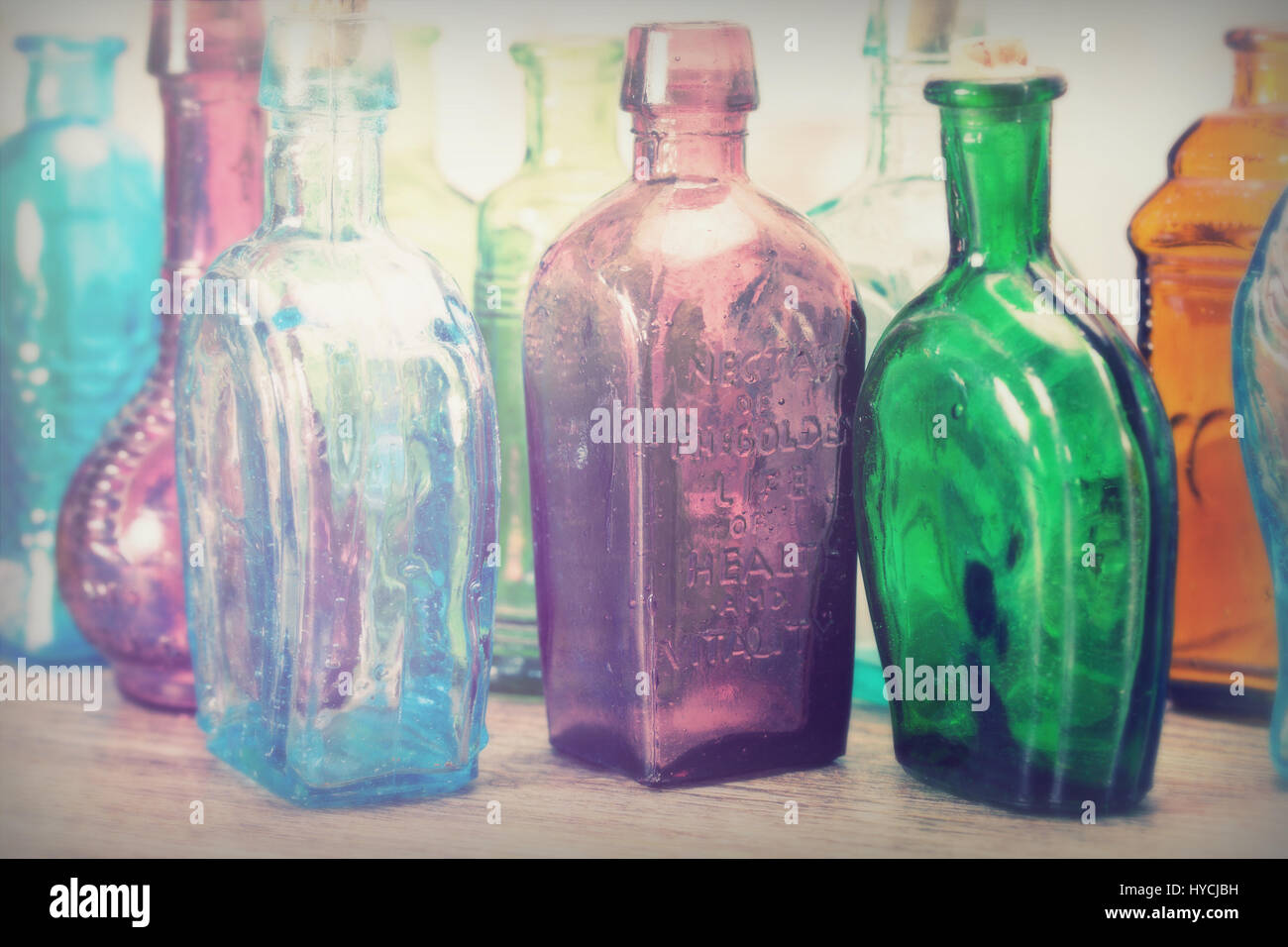 Selection of coloured glass bottles on a rustic background Stock Photo ...
