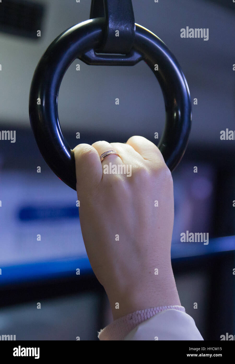 people holding onto a handle on a bus Stock Photo - Alamy