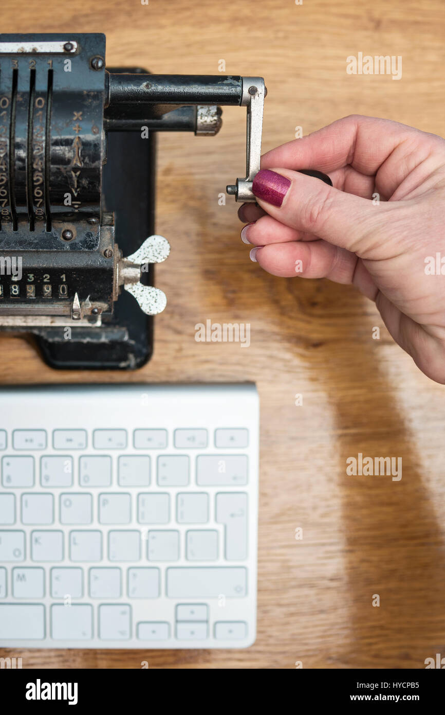 Female hand turninghandle of an adding machine Stock Photo - Alamy