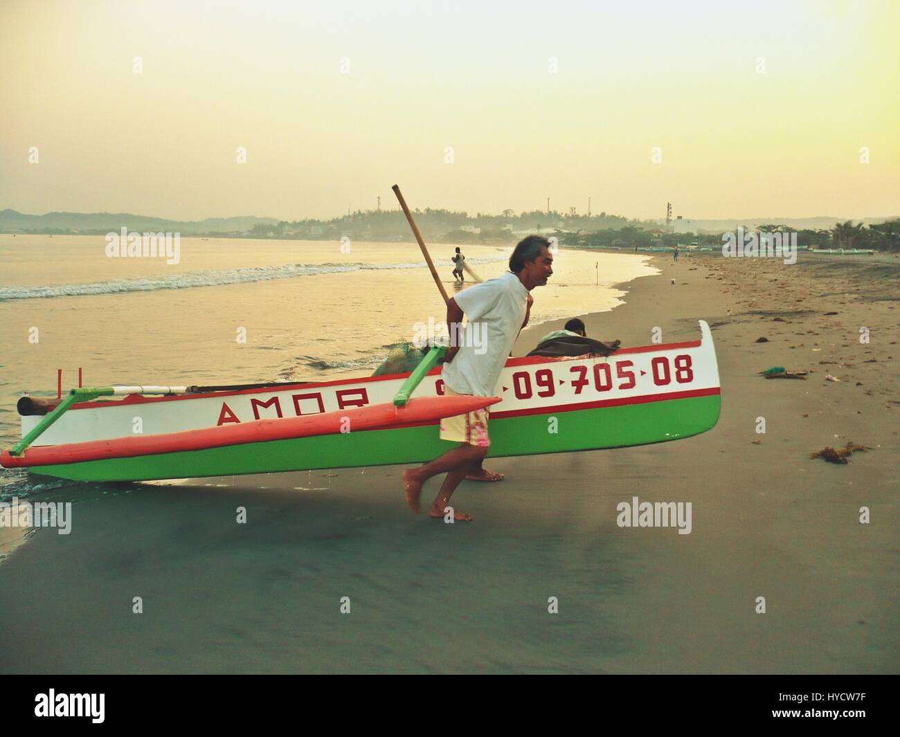 A fisherman's help pulling a fishing boat to shore after the day's ...