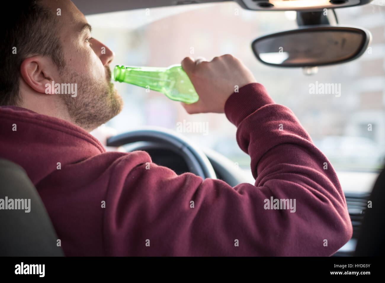 Drunk man driving his car and drinking alcohol Stock Photo - Alamy
