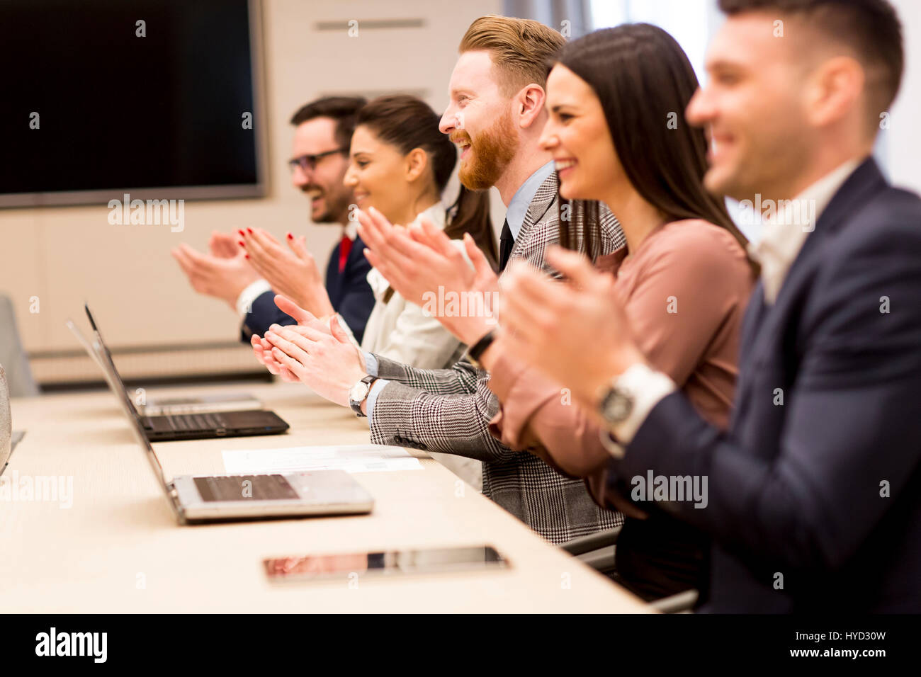 Happy smiling business team clapping hands during a meeting in office ...
