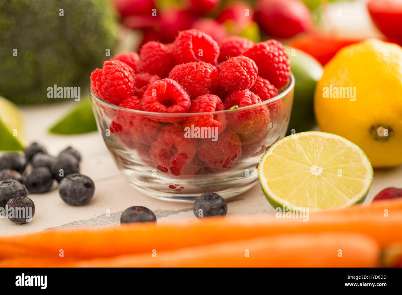 Raspberries in bowl surrounded by fruits and vegetables Stock Photo - Alamy