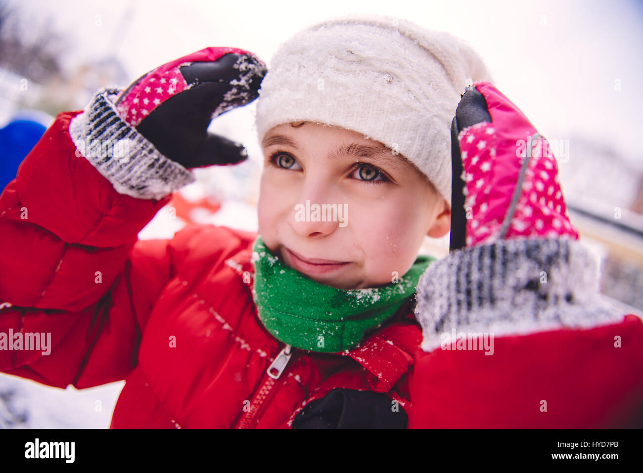 Little girl wearing red jacket and white hat playing in the snow Stock ...