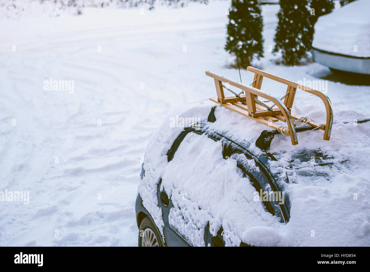 Snow covered car with sled on the roof rack Stock Photo - Alamy
