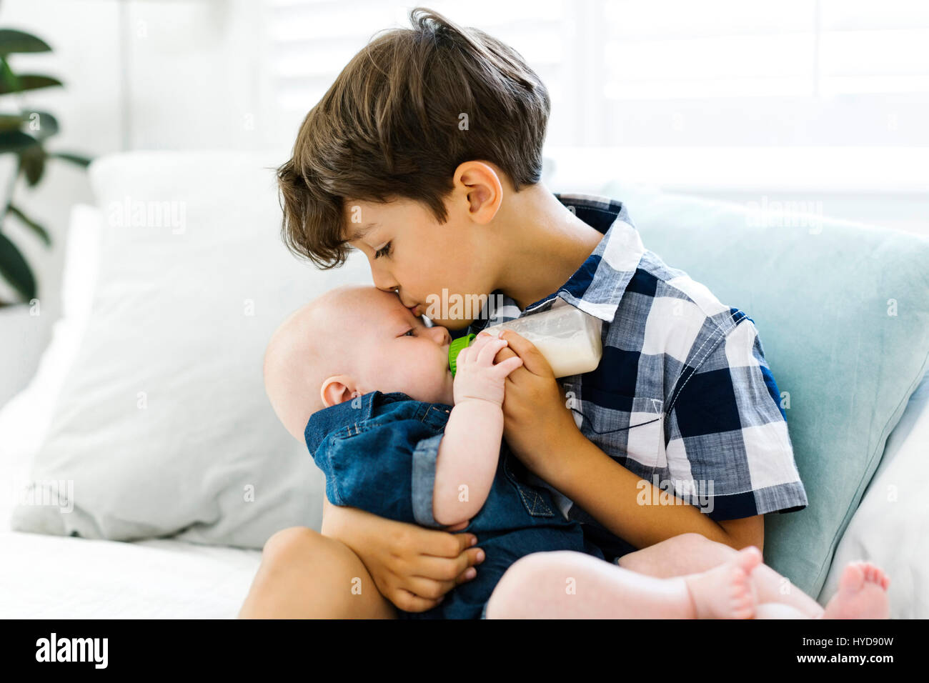 Boy( 6-7) feeding small brother (12-17 months Stock Photo - Alamy