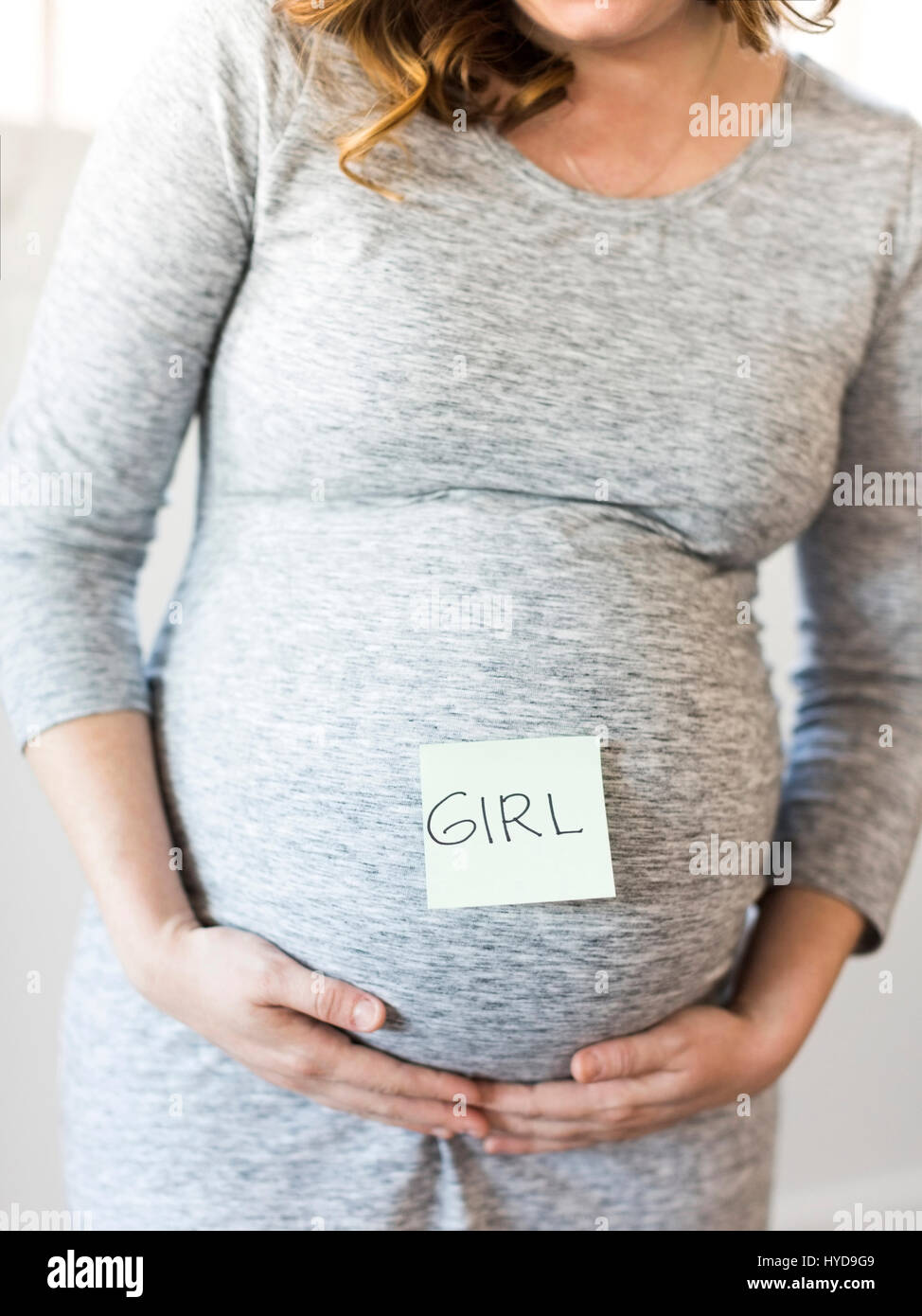 Portrait of smiling pregnant woman with adhesive note on belly Stock ...
