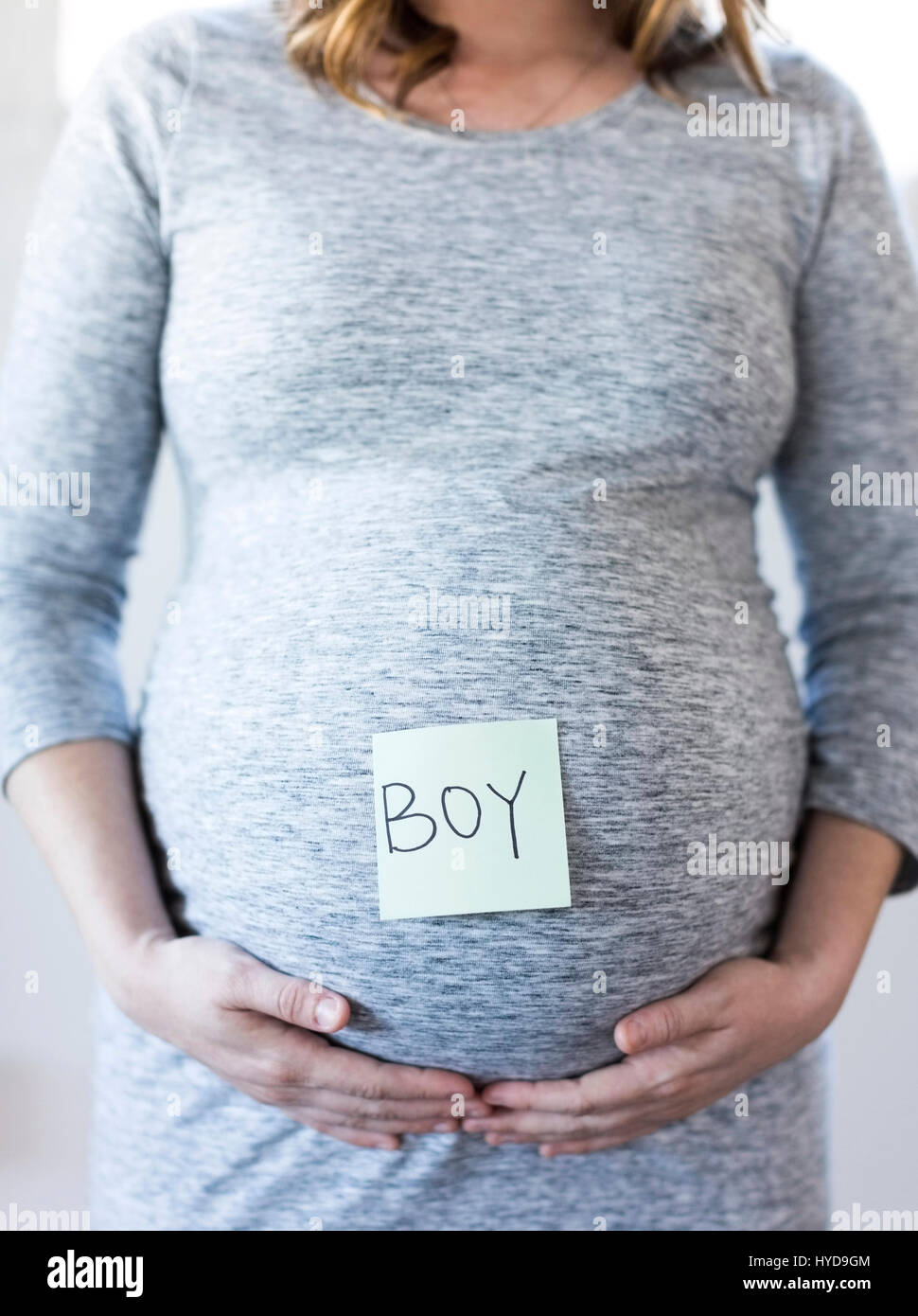 Portrait of smiling pregnant woman with adhesive note on belly Stock ...