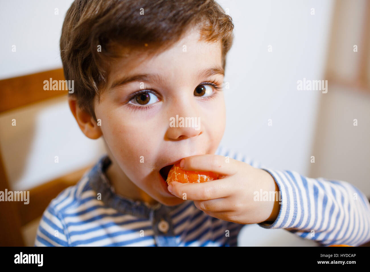 4-years boy eat a mandarin with great pleasure Stock Photo - Alamy