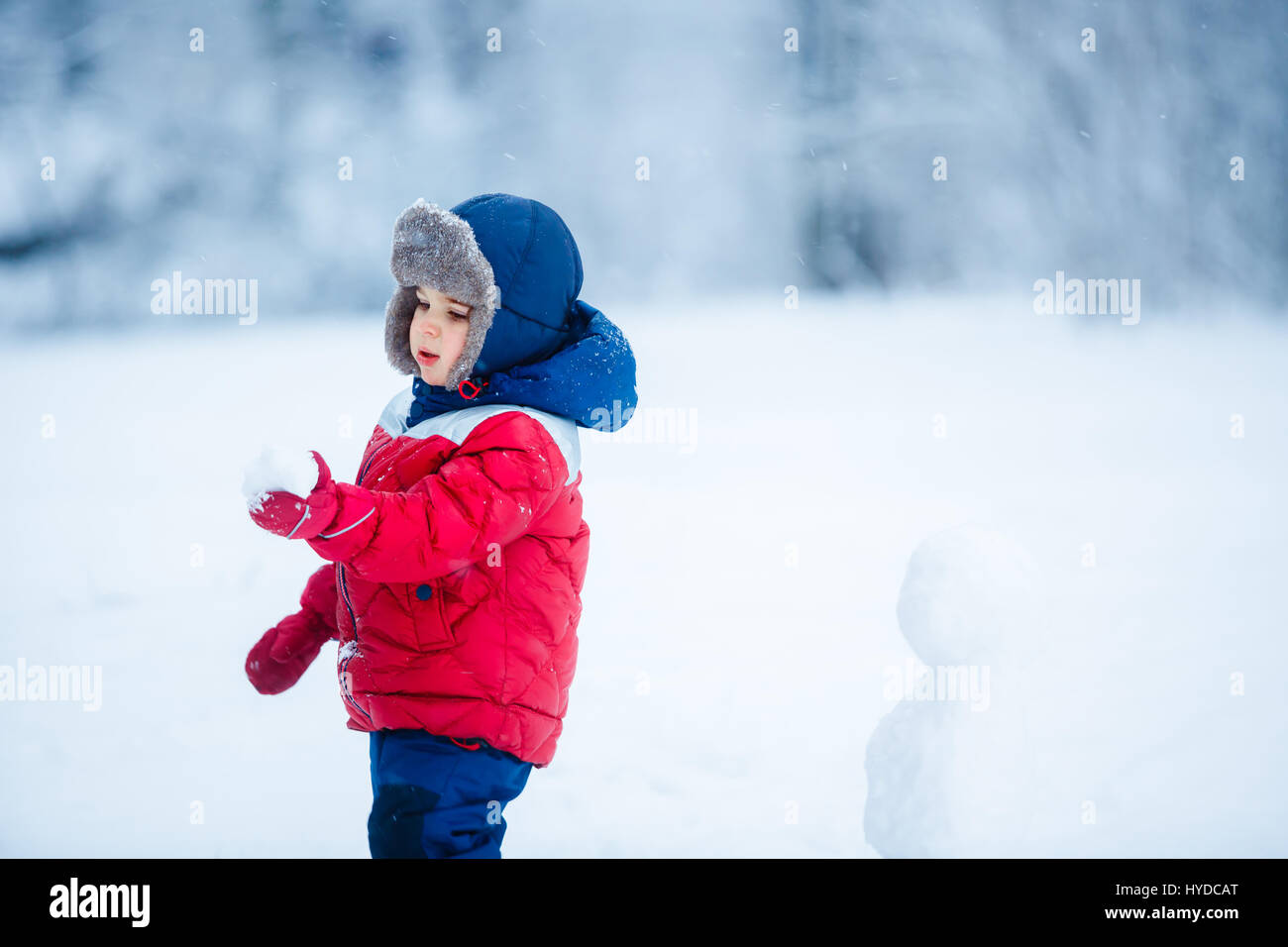 Adorable boy having fun with snow on winter day Stock Photo - Alamy