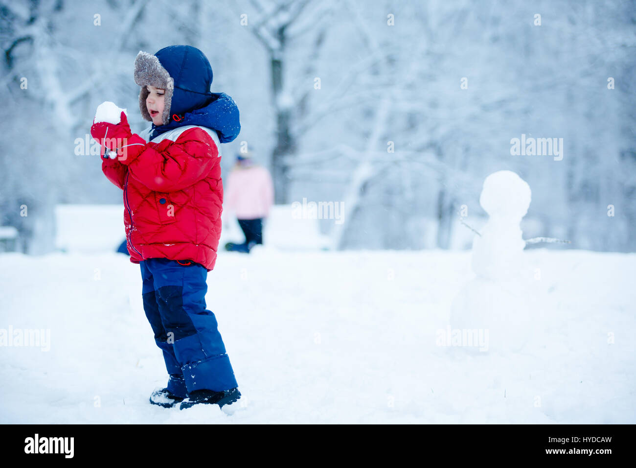 Adorable boy having fun with snow on winter day Stock Photo - Alamy