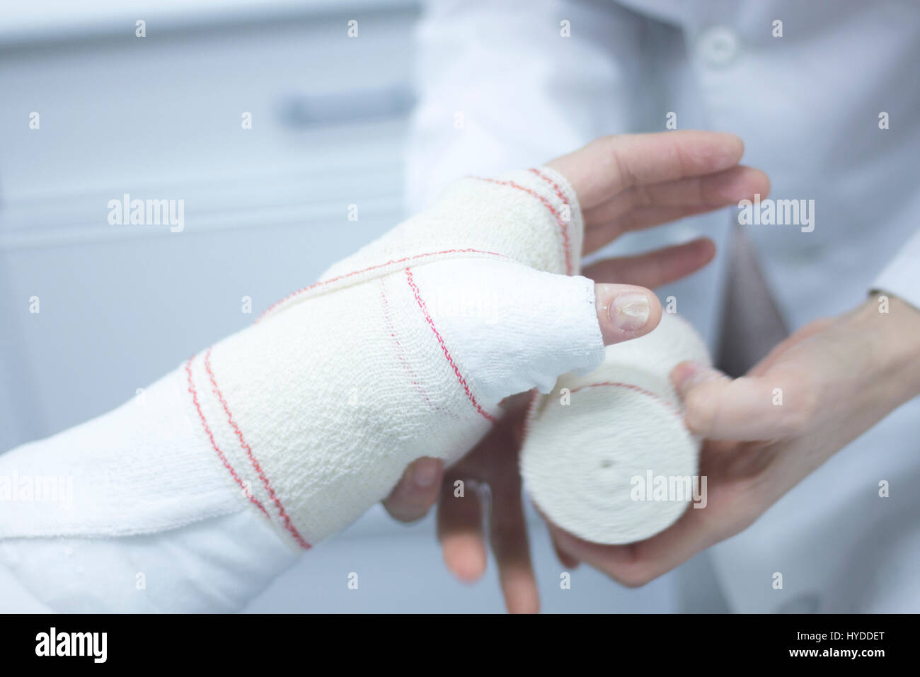 Doctor applying a plaster cast and bandages to patient forearm and ...