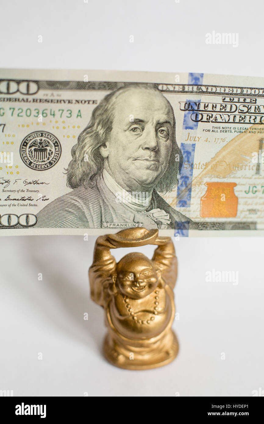 a small golden buddha figurine standing on a white back ground holds a ...