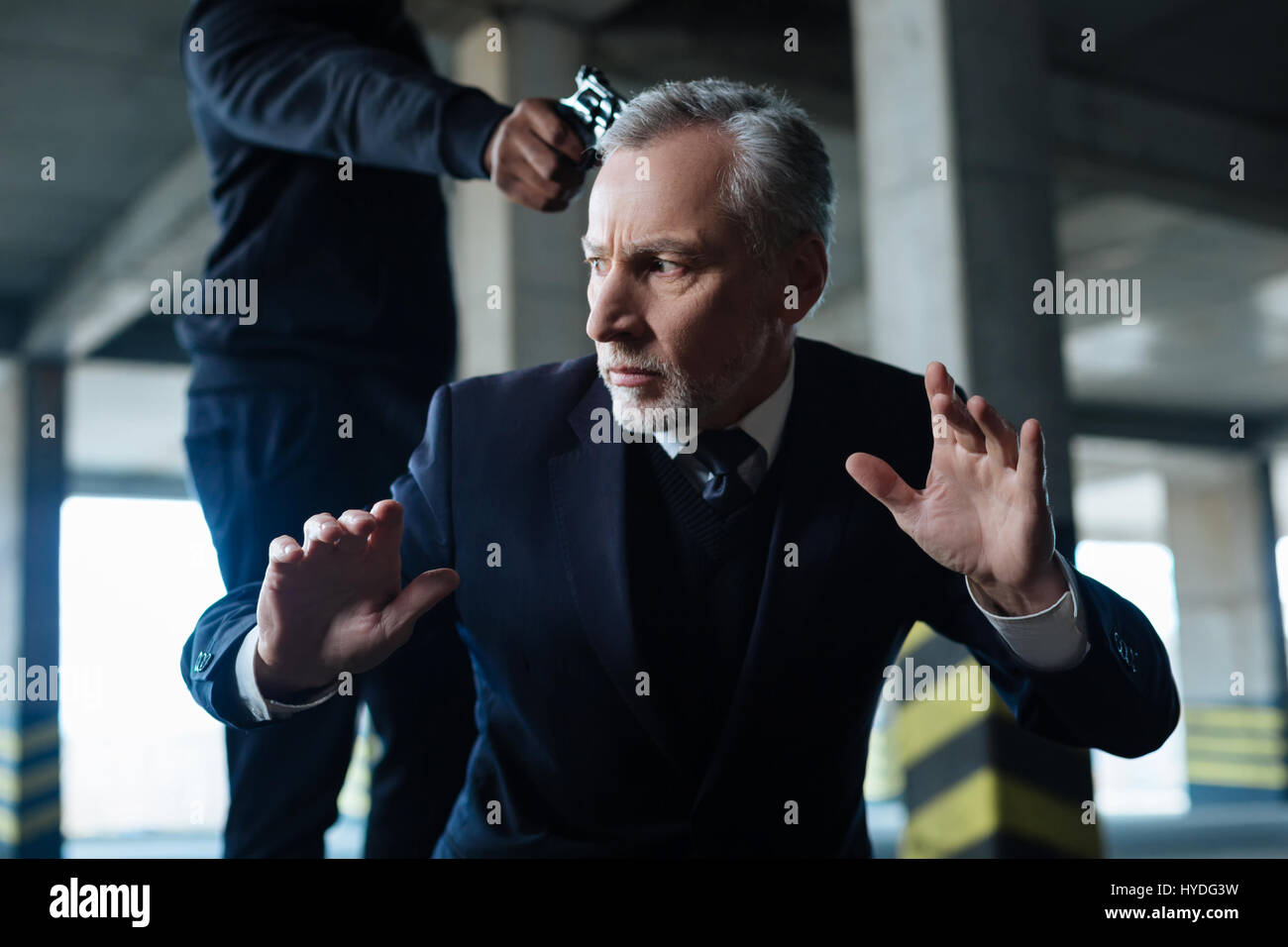 Frightened rich businessman doing commands of a kidnapper Stock Photo ...