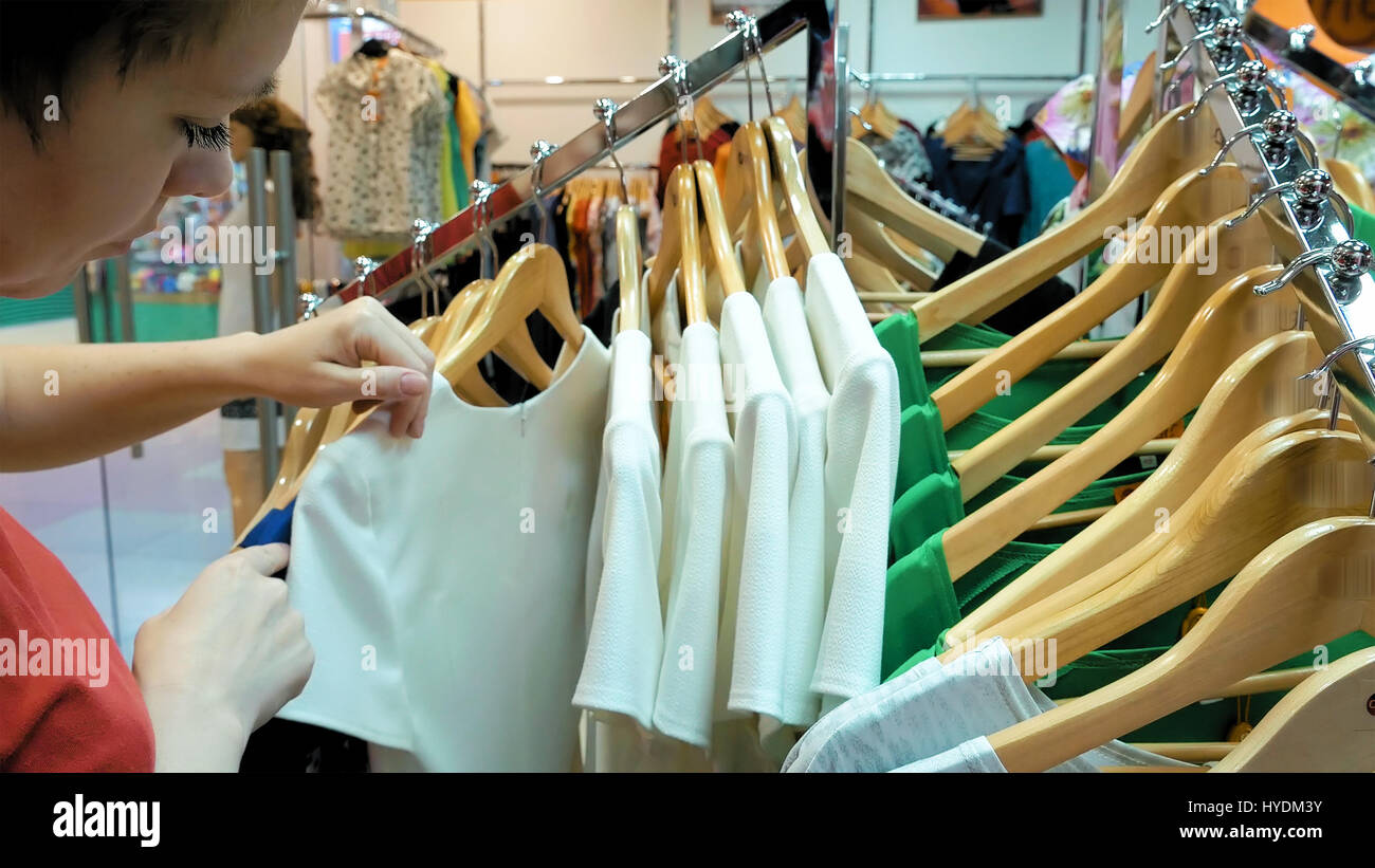 A female customer is browsing through the cloths Stock Photo - Alamy