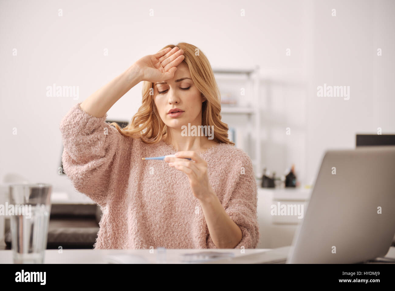 Weakened young office manager having high temperature in the office ...