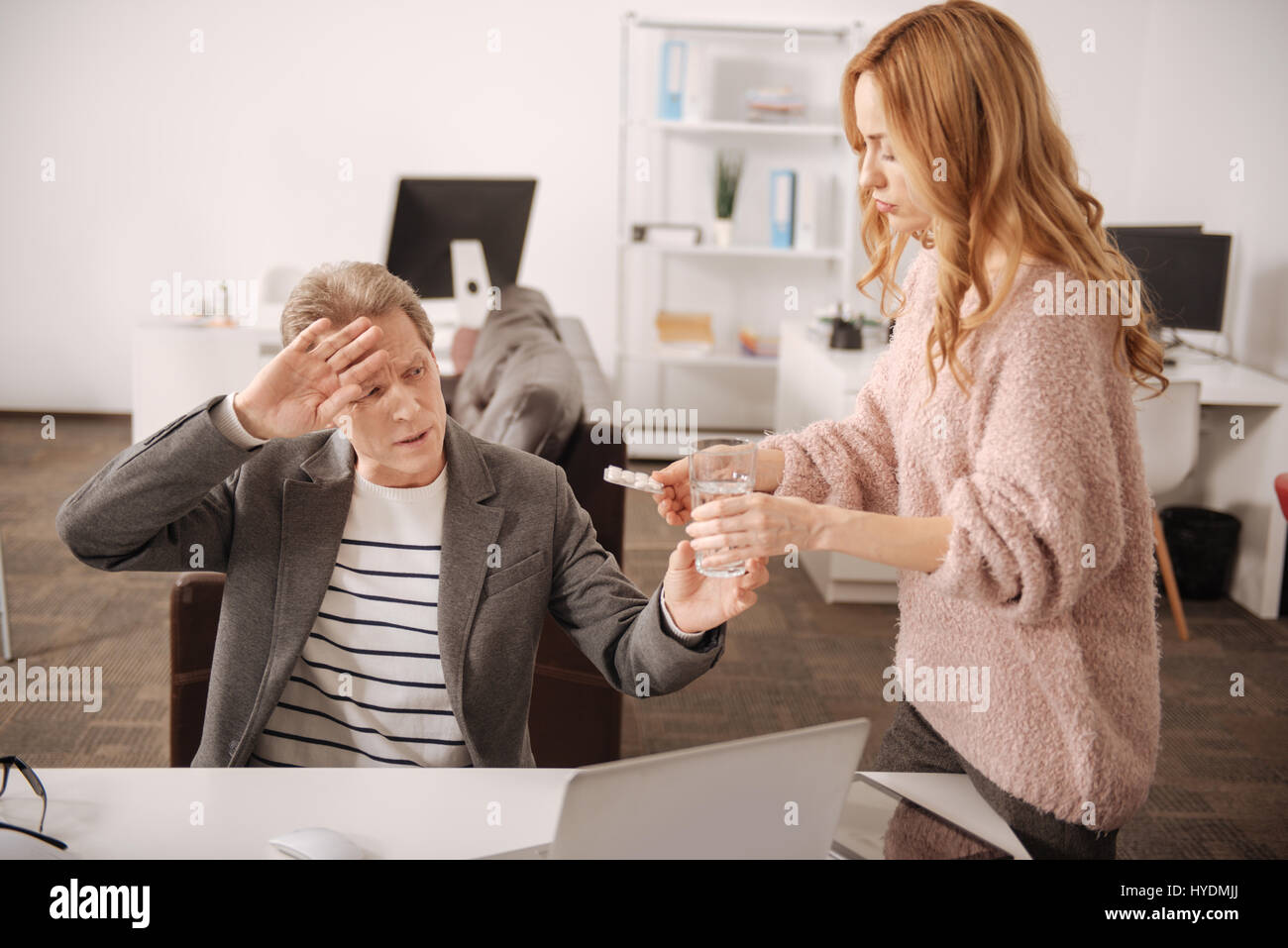 Helpful secretary offering help to ill boss in the office Stock Photo ...