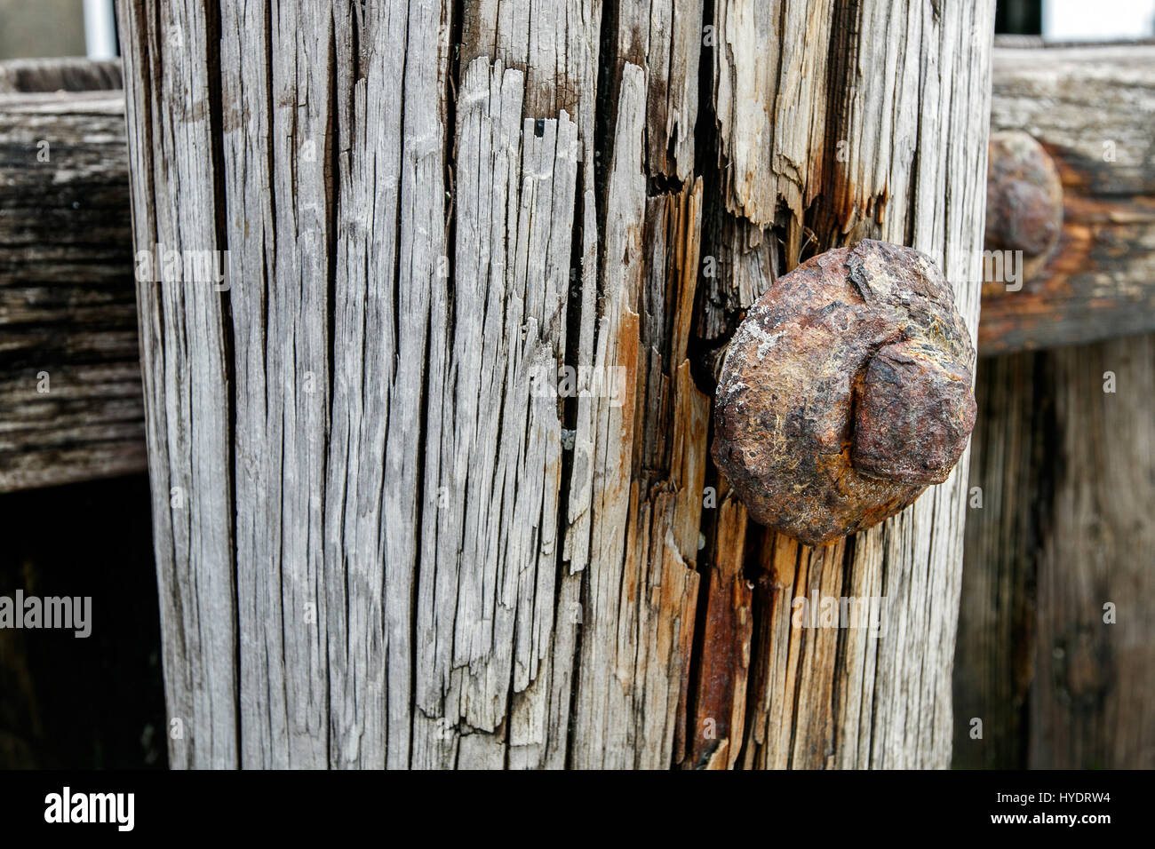 Old rusty timber bolt inside a wooden pylon of what used to be a pier ...