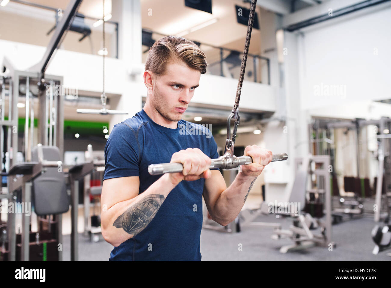 Fit young man in gym working out on pull-down machine Stock Photo - Alamy