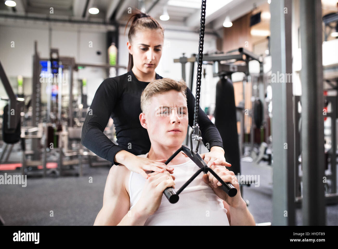 Fit young man in gym working out on pull-down machine Stock Photo - Alamy