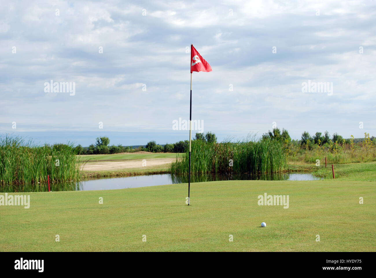 golf course with red flag and ball Stock Photo - Alamy