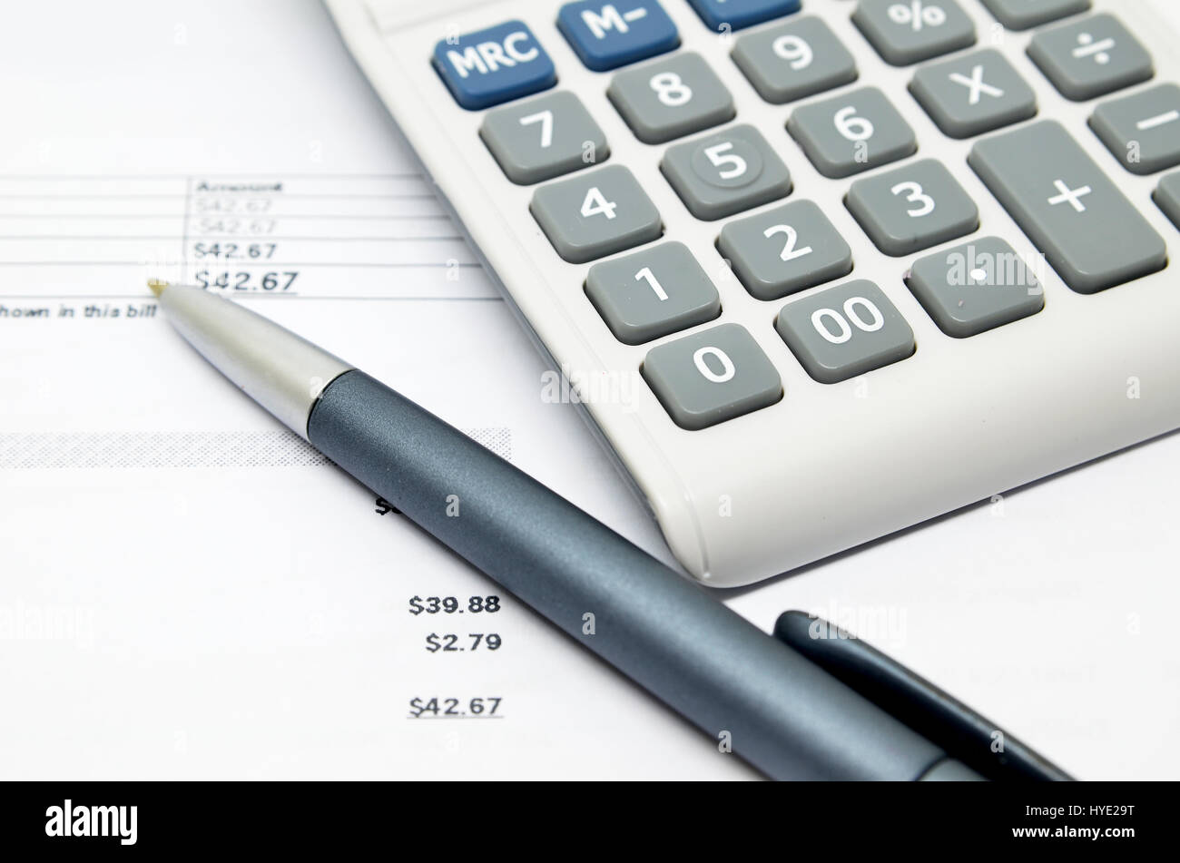Pen on background of calculator and bill Stock Photo - Alamy