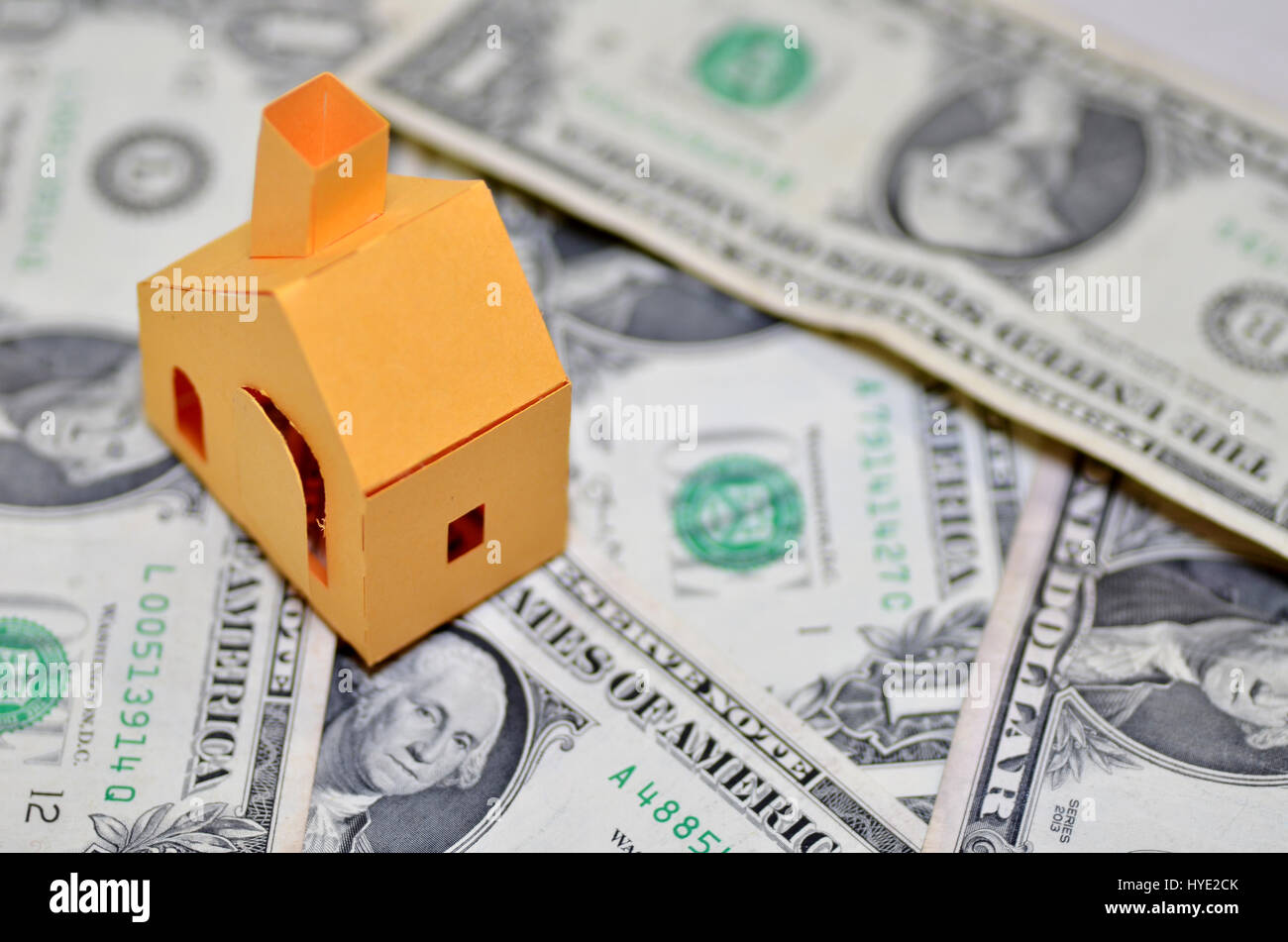 Paper made house stands on dollar money Stock Photo - Alamy