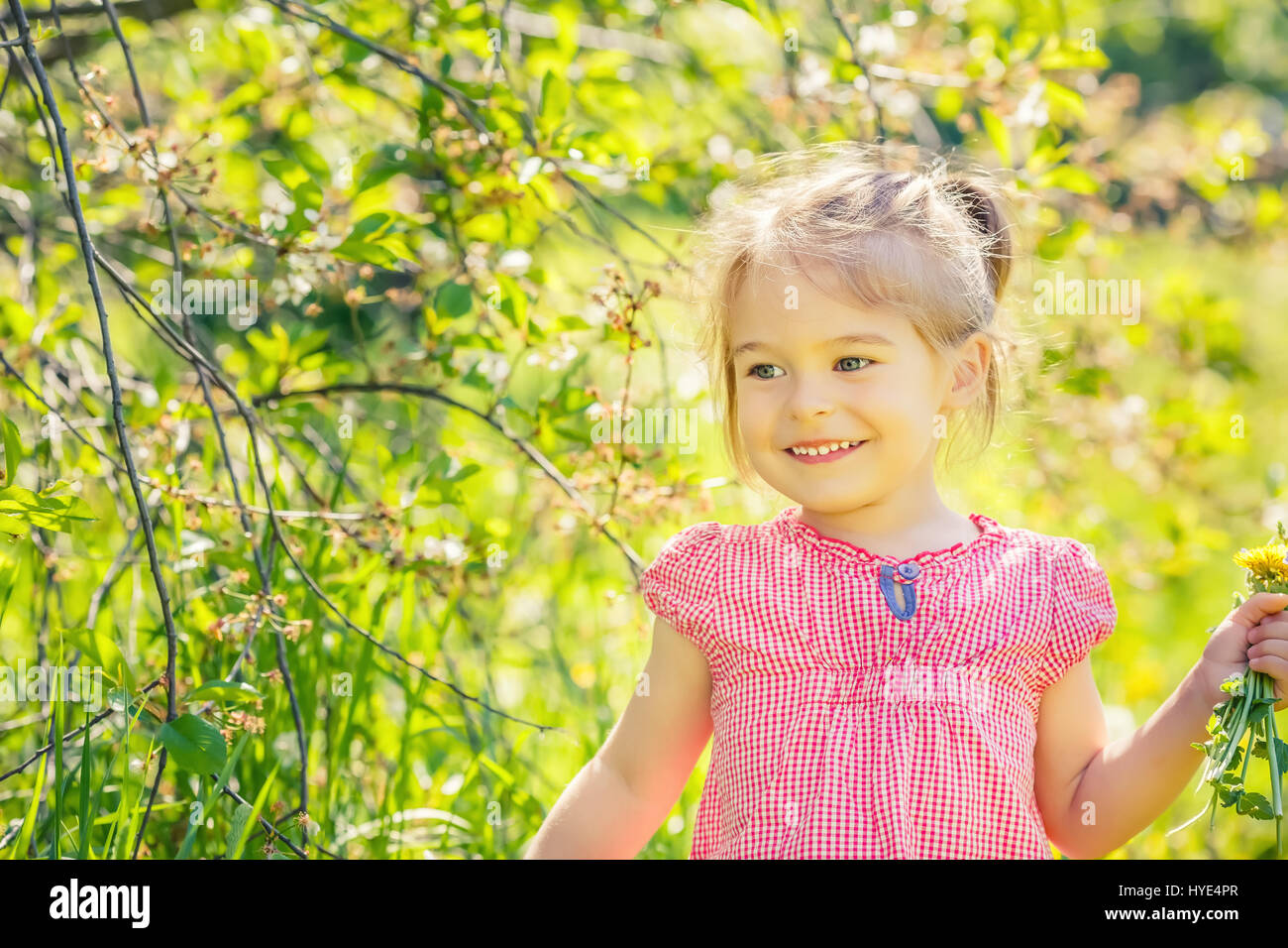 Happy little girl in spring sunny park Stock Photo - Alamy