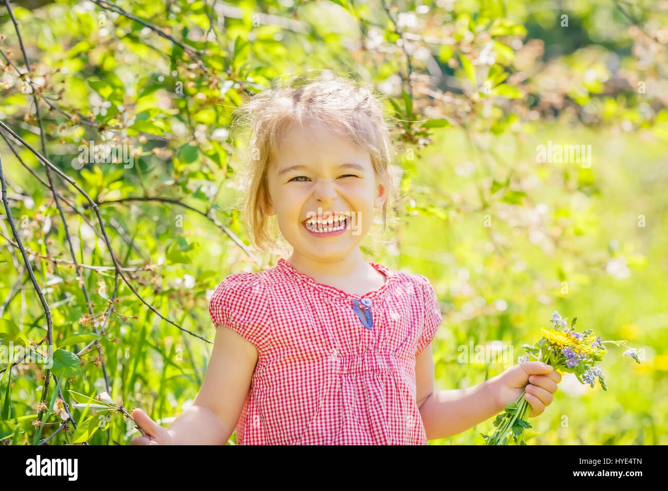 Happy little girl in spring sunny park Stock Photo - Alamy