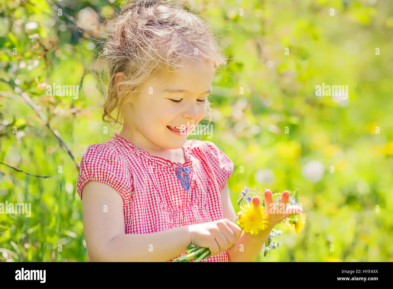 Happy little girl in spring sunny park Stock Photo - Alamy