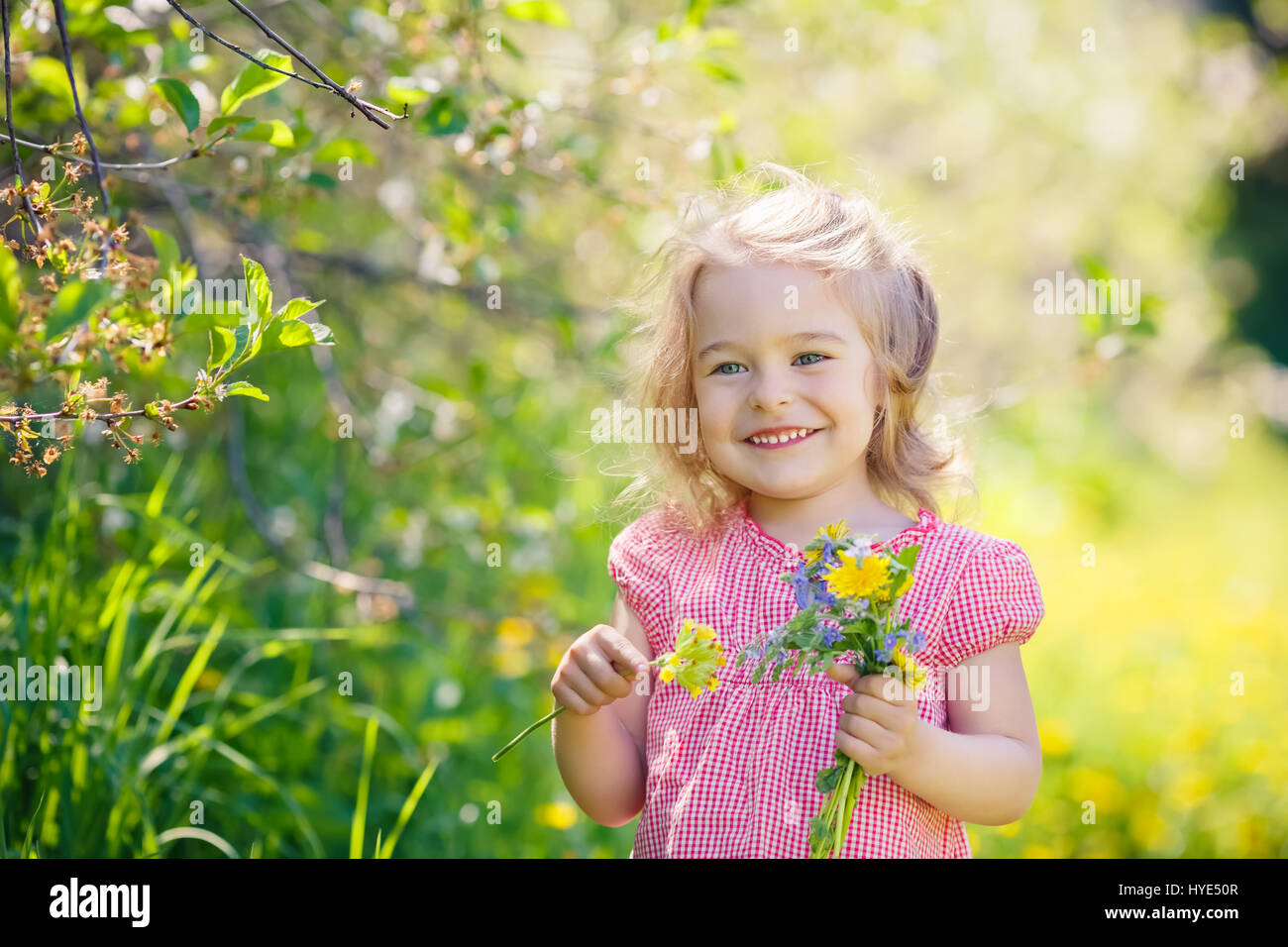 Happy little girl in spring sunny park Stock Photo - Alamy
