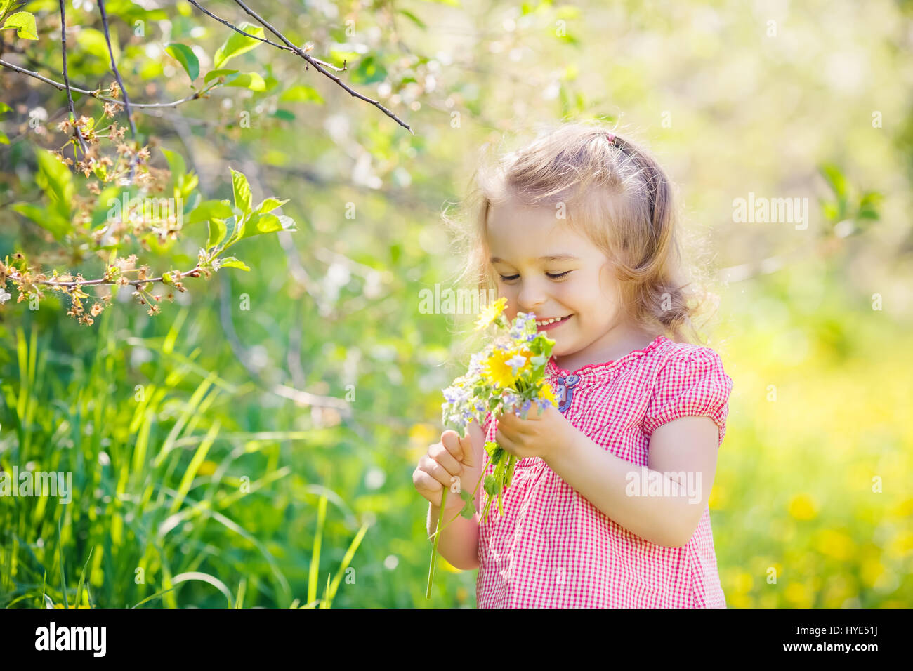 Happy little girl in spring sunny park Stock Photo - Alamy