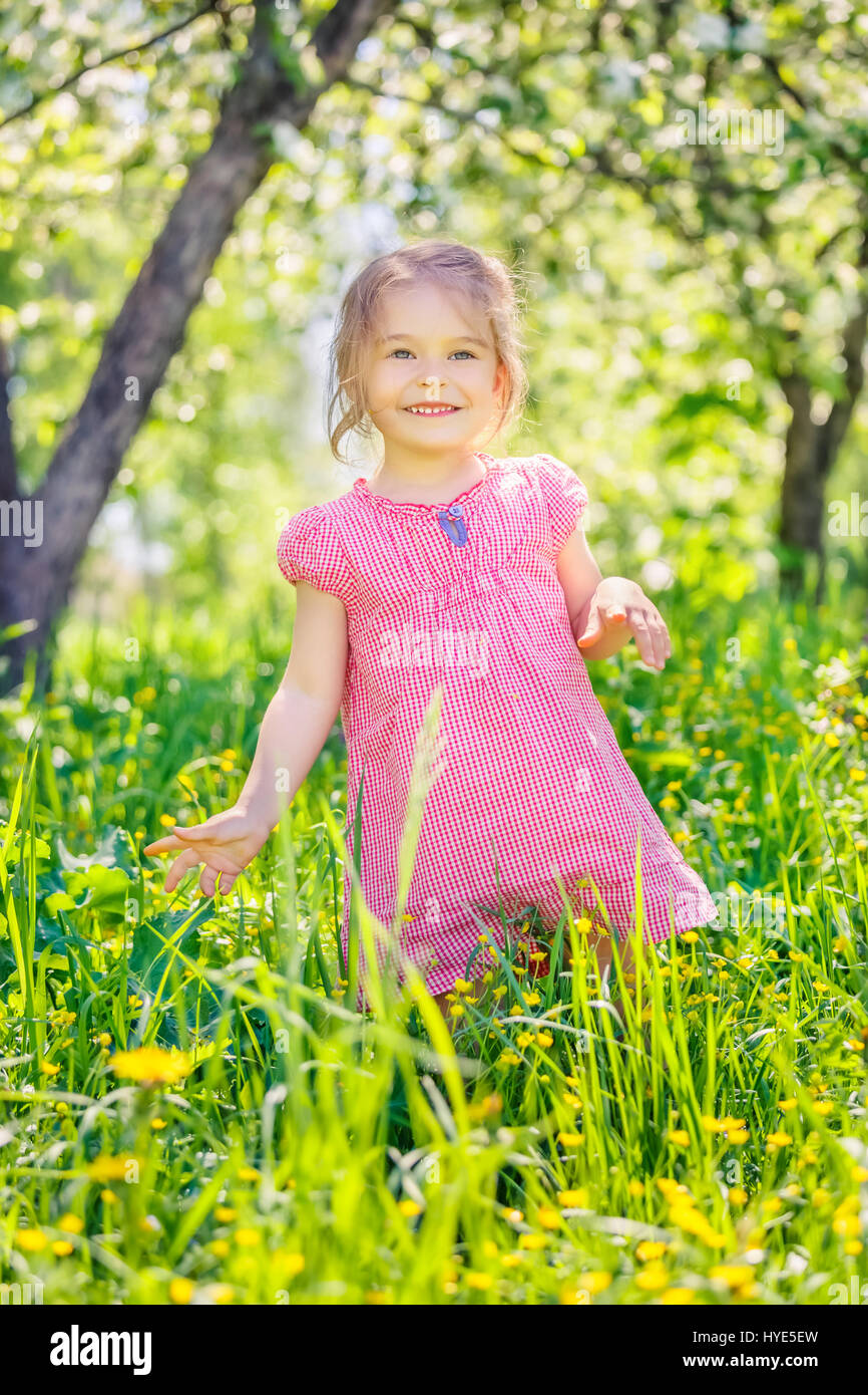 Happy little girl in spring garden Stock Photo - Alamy
