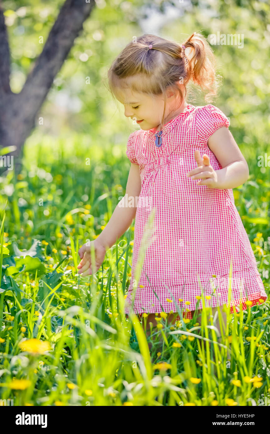 Happy little girl in spring garden Stock Photo - Alamy